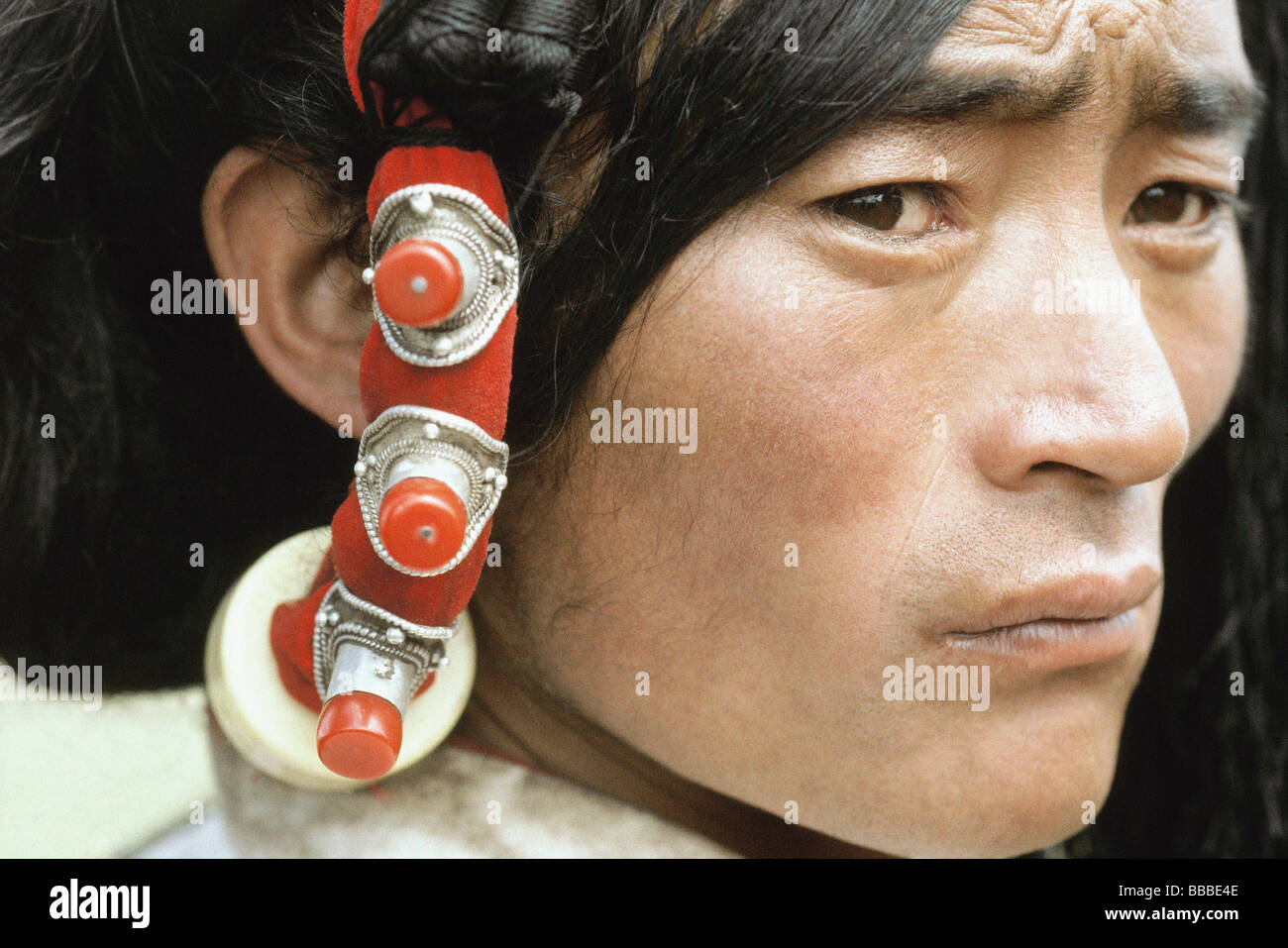 China, Szechuan (Sichuan), Kham region, A Khampa man wears traditional ...