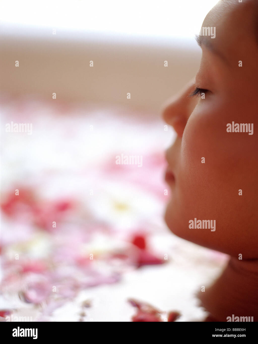Woman in bath with floating flowers, profile Stock Photo - Alamy