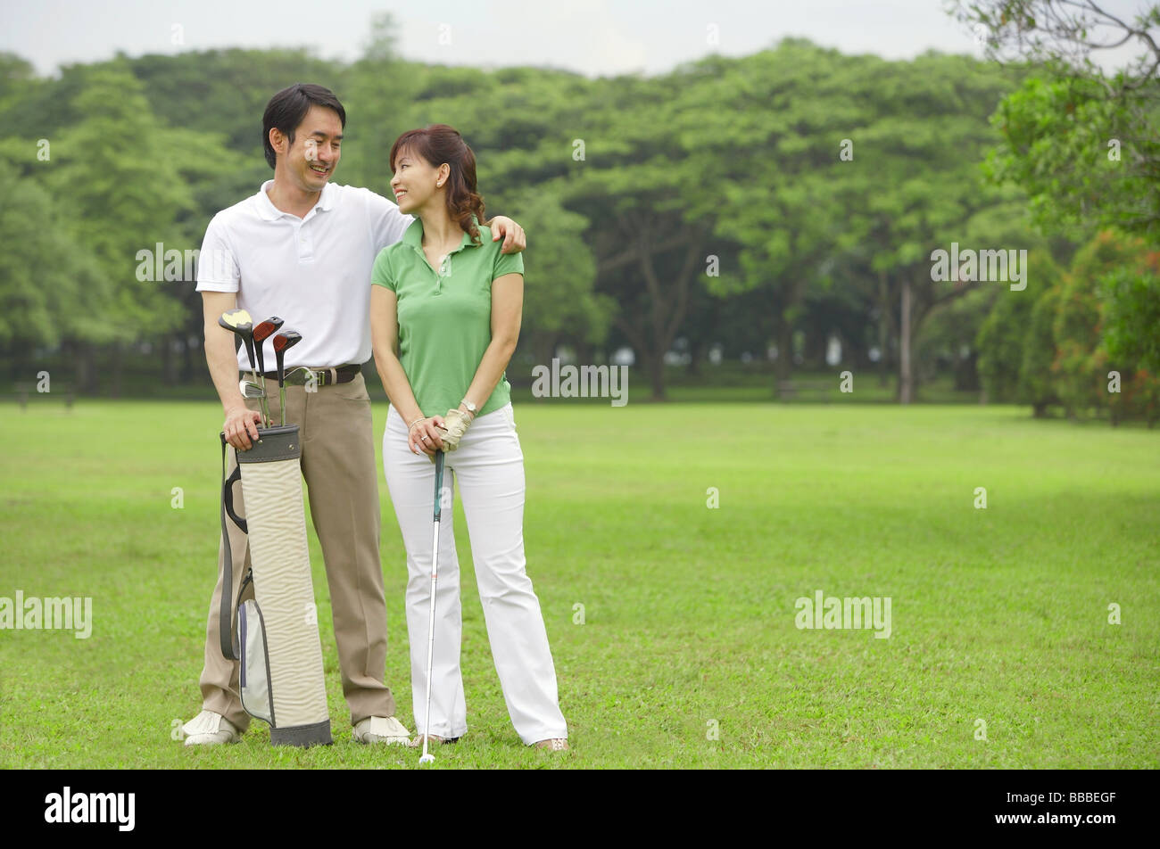 Couple on golf course, smiling at each other Stock Photo - Alamy