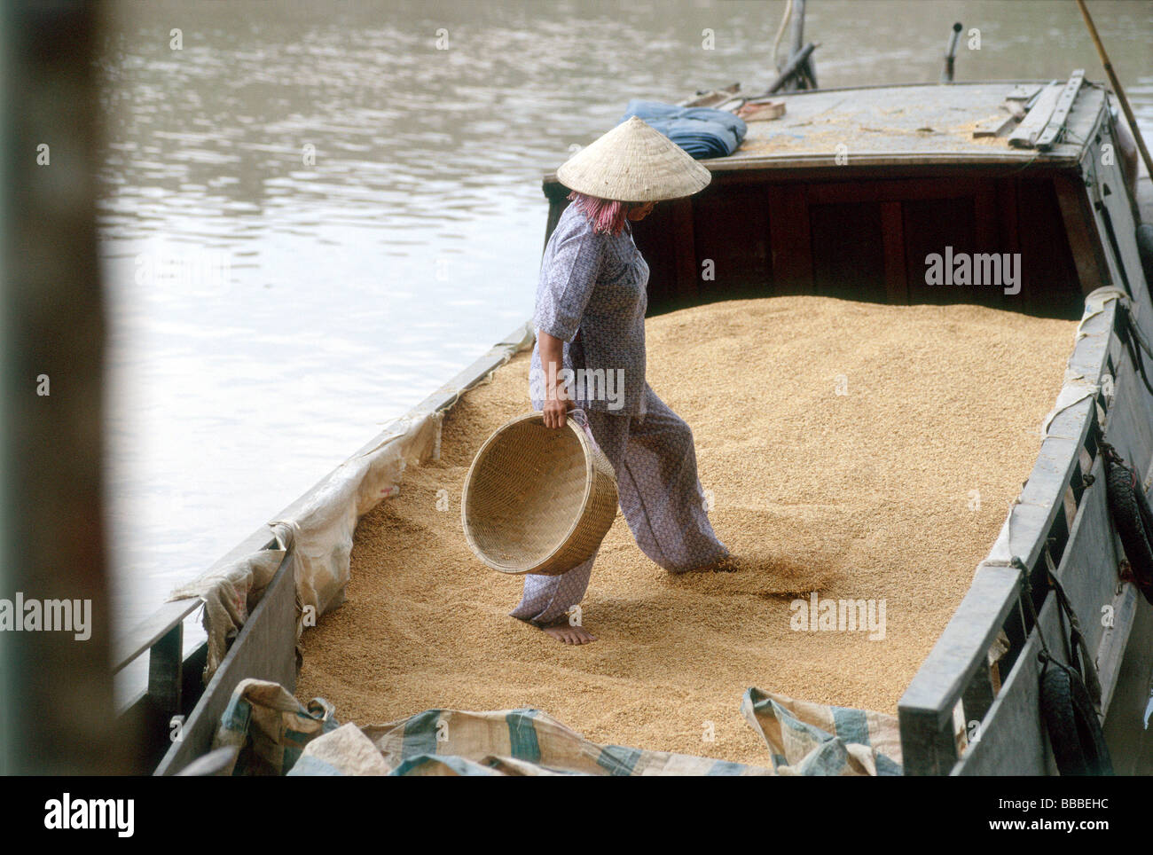 Vietnam, Mekong Delta, woman working on rice boat Stock Photo - Alamy