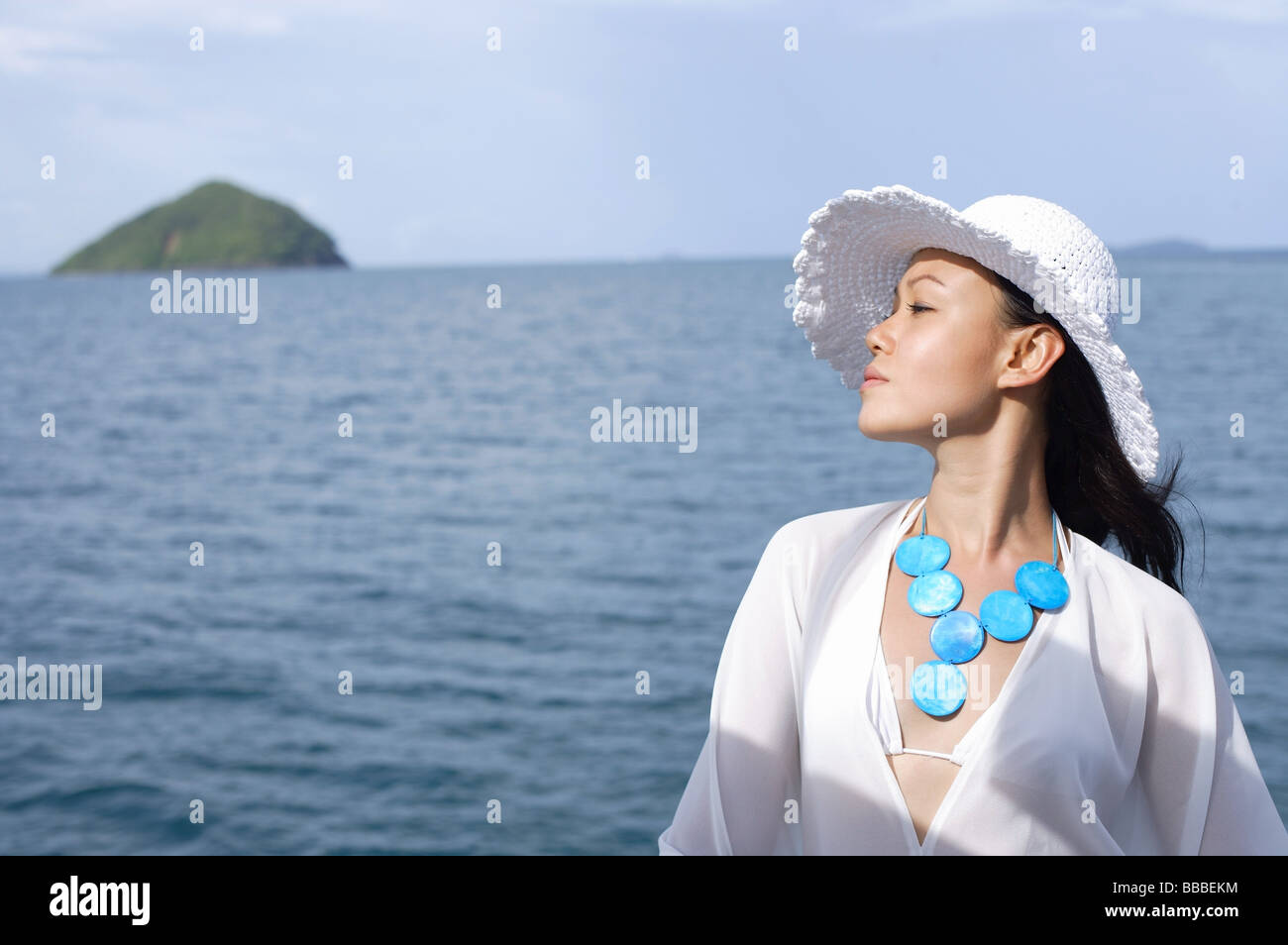 Woman wearing white hat, in profile, ocean behind her Stock Photo - Alamy