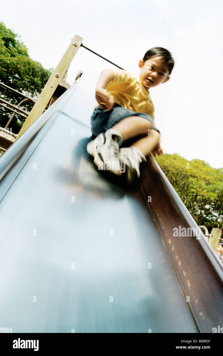Boy going down slide Stock Photo - Alamy