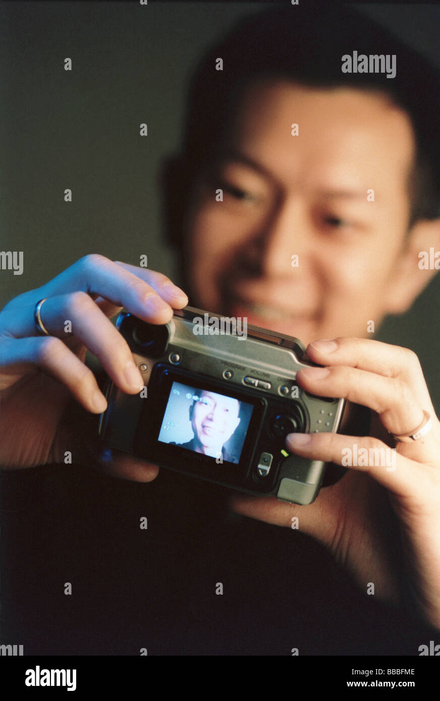 Man holding digital camera, black background ( high grain Stock Photo ...