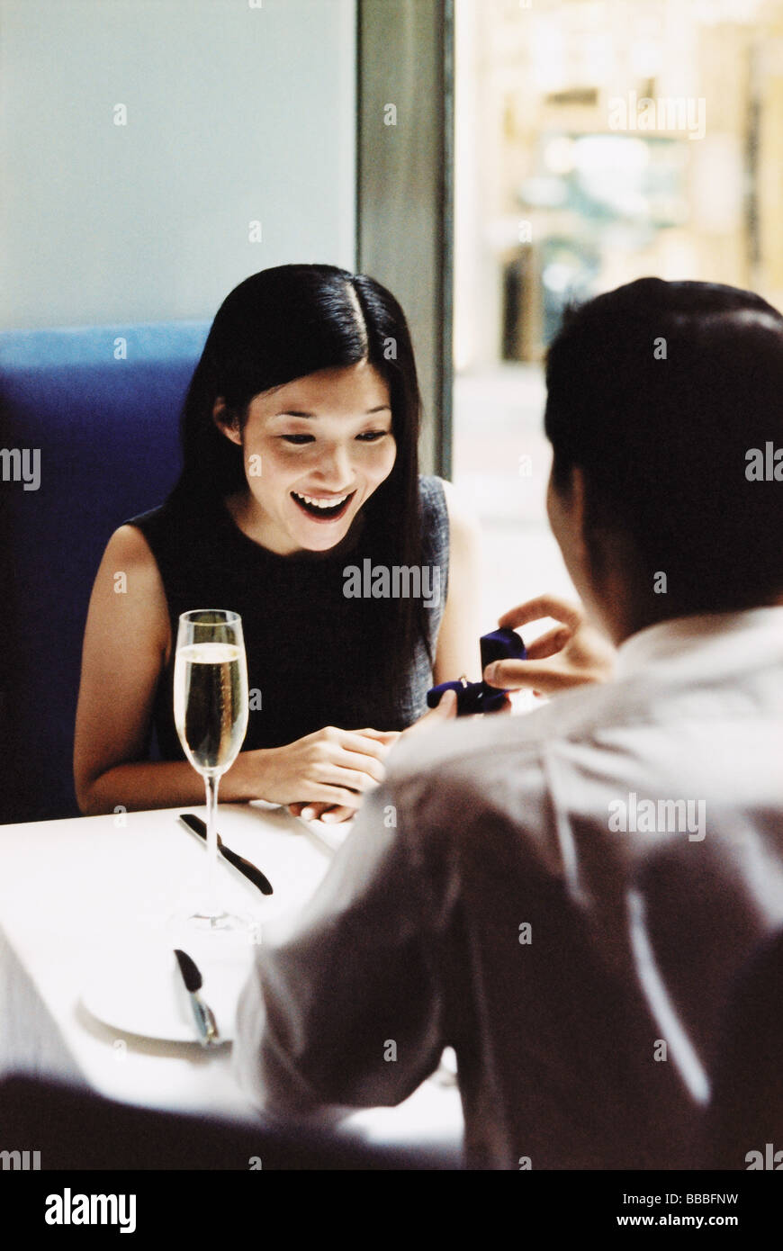 Man presenting engagement ring to woman in restaurant Stock Photo - Alamy