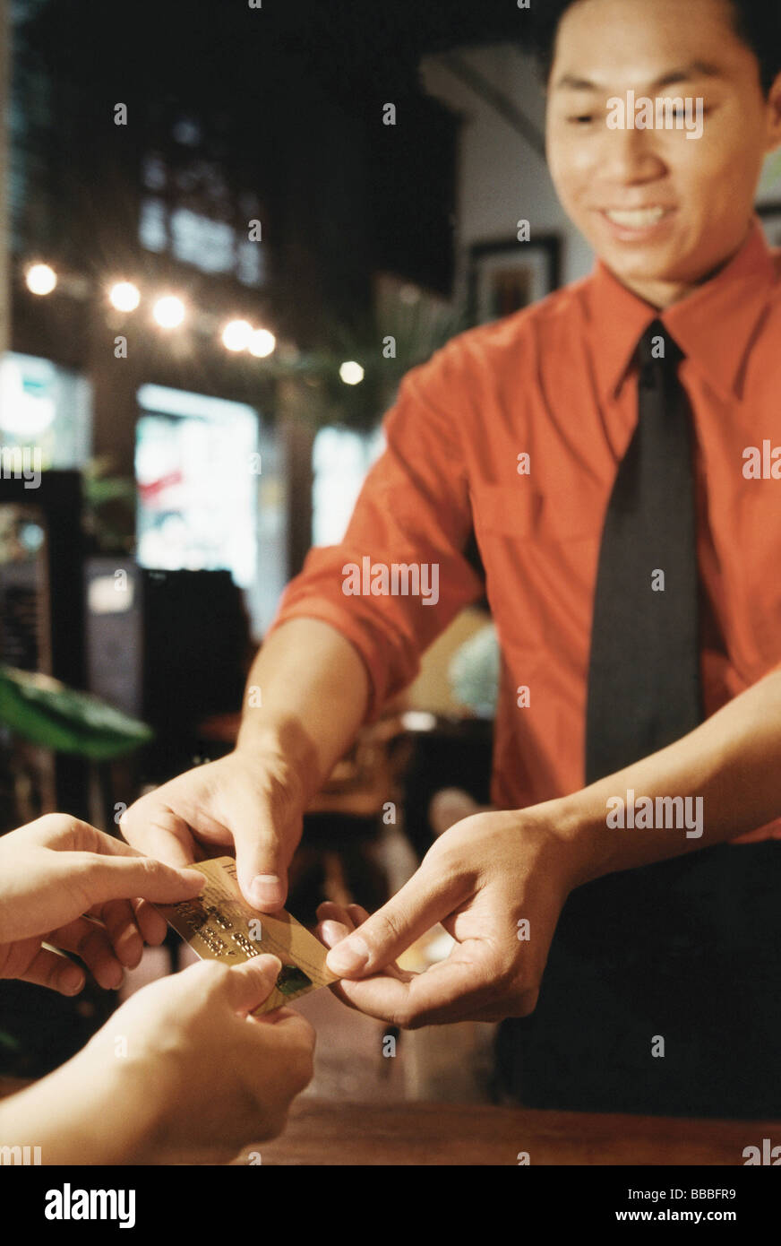 Man giving credit card to salesperson in store Stock Photo - Alamy