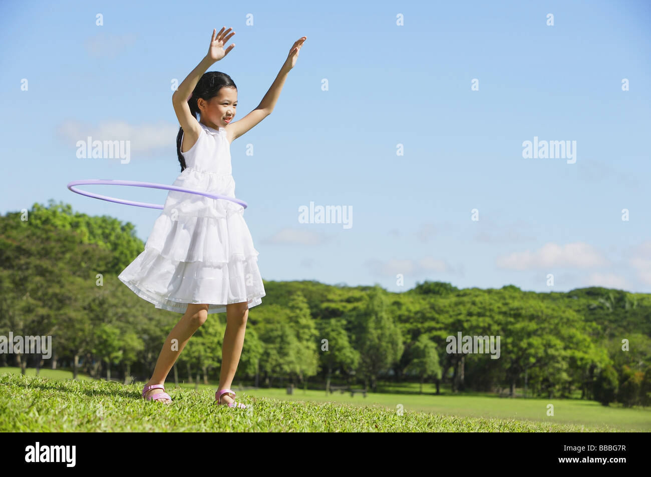 Girl in park using hoola hoop Stock Photo - Alamy