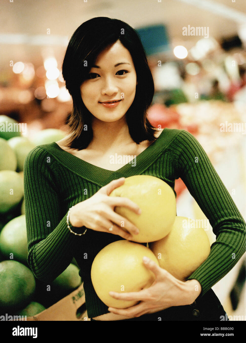 Young woman holding fruit, portrait Stock Photo - Alamy
