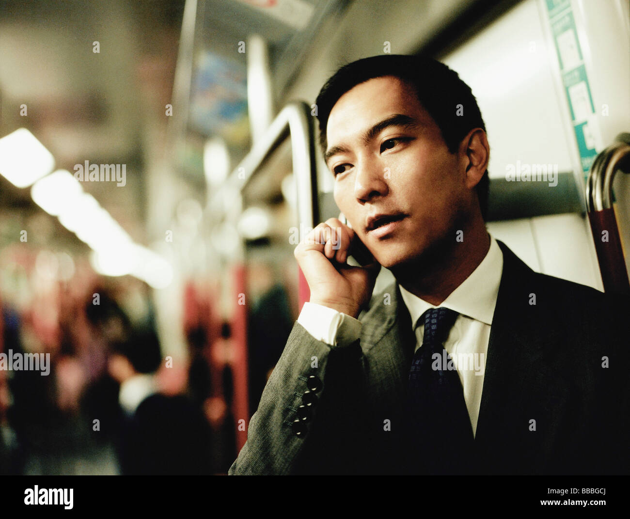 Executive using cellular phone in train Stock Photo - Alamy