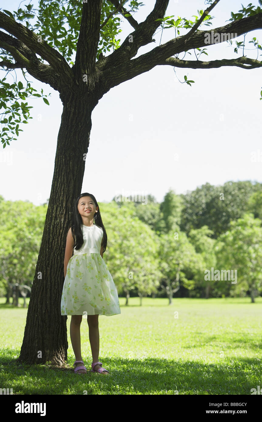 Girl in park, standing under tree Stock Photo - Alamy