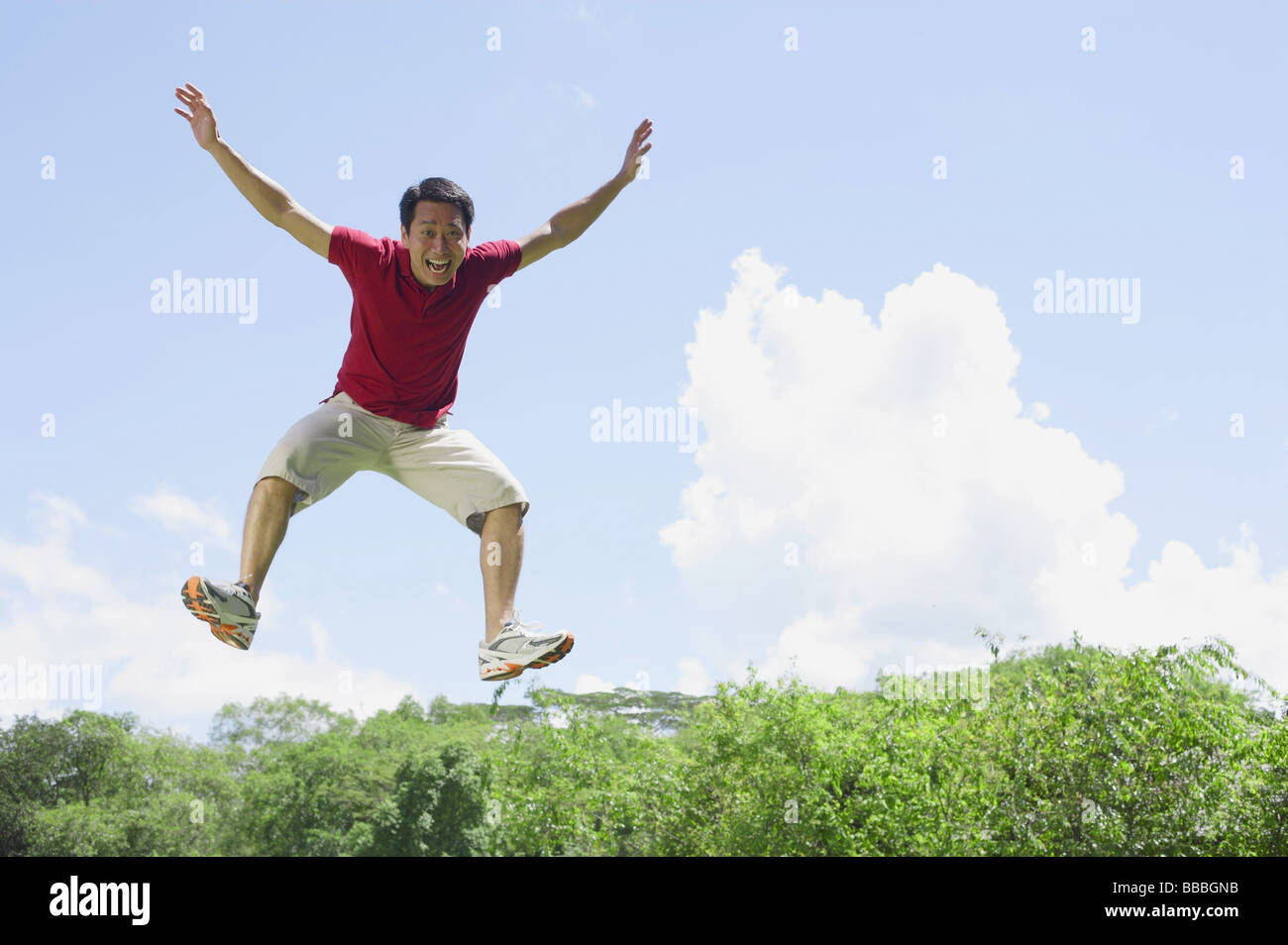 Man jumping in mid air, arms outstretched Stock Photo - Alamy