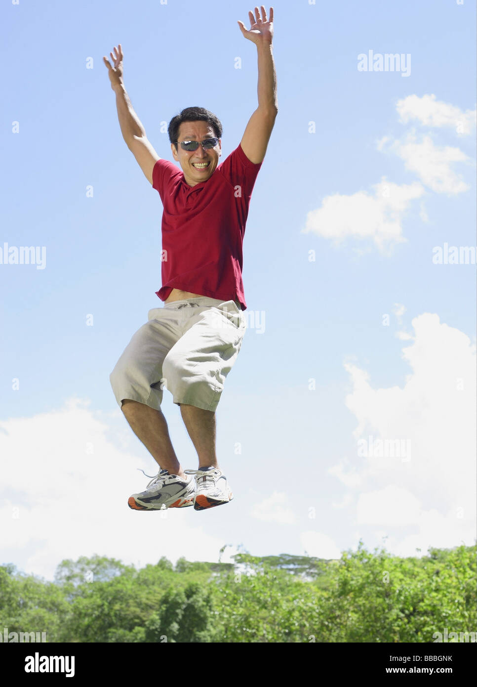 Man jumping in mid air, arms outstretched, smiling Stock Photo - Alamy
