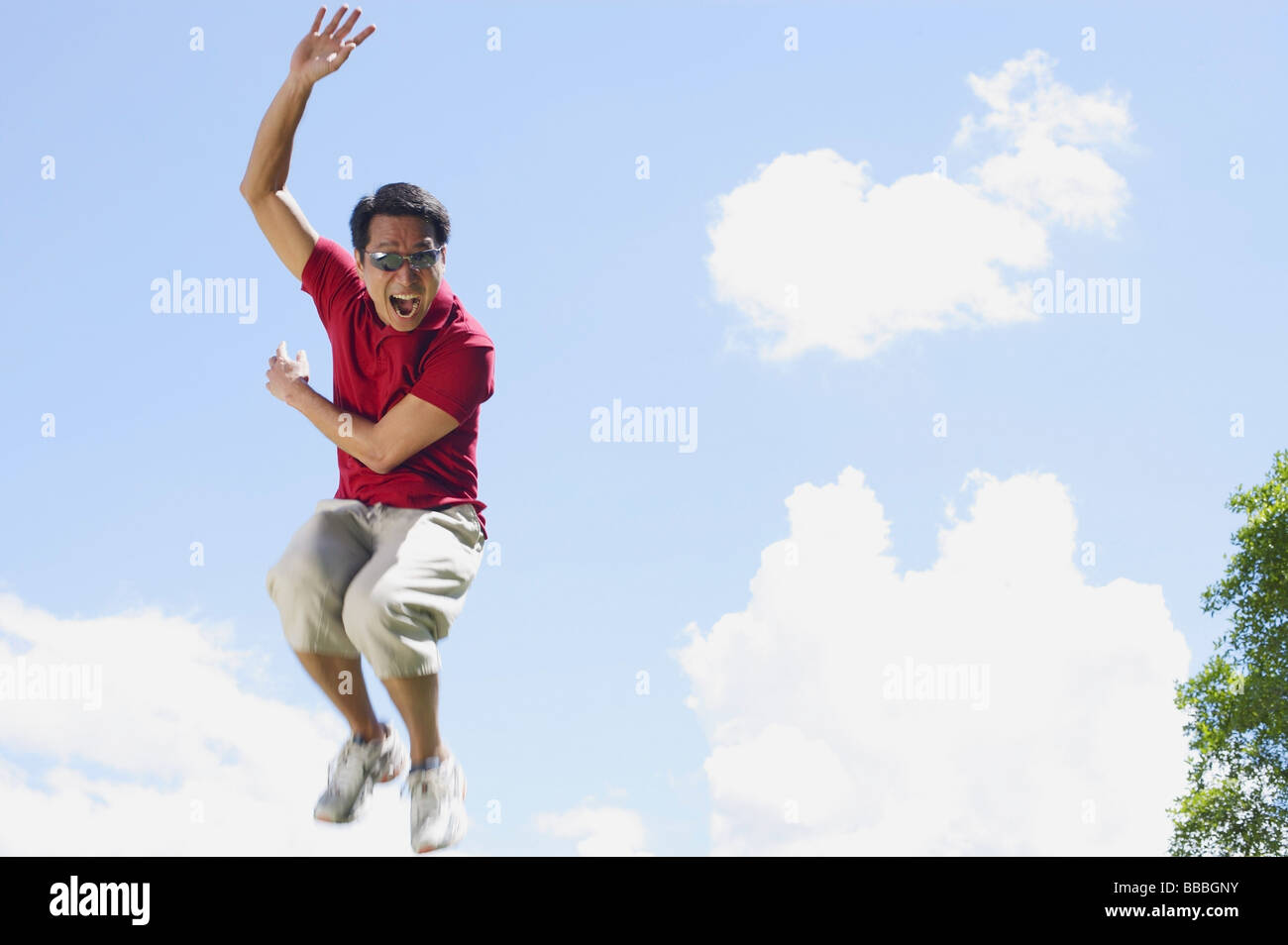 Man jumping in mid air, hand raised, mouth open Stock Photo - Alamy