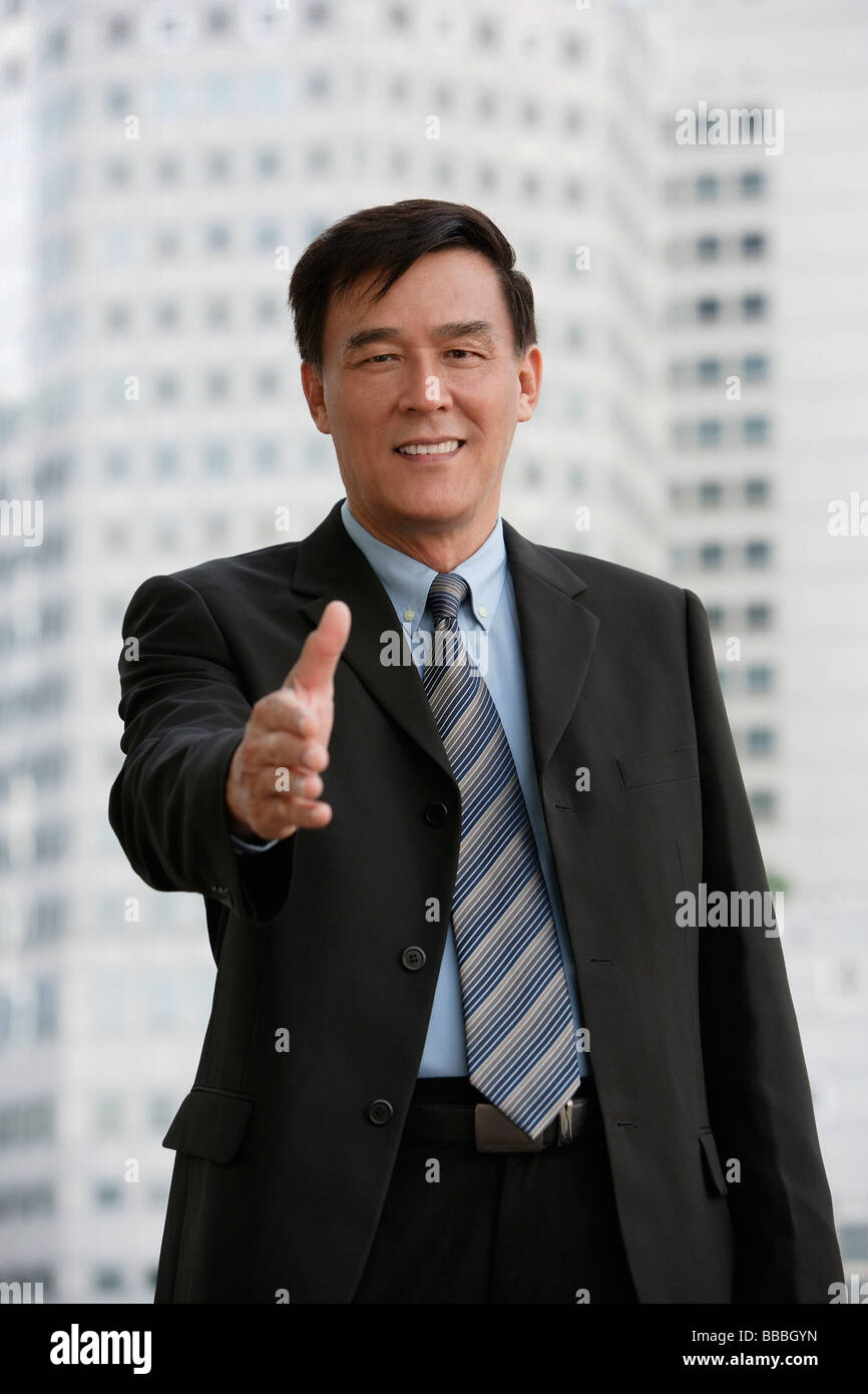 Businessman reaching out hand for handshake Stock Photo - Alamy