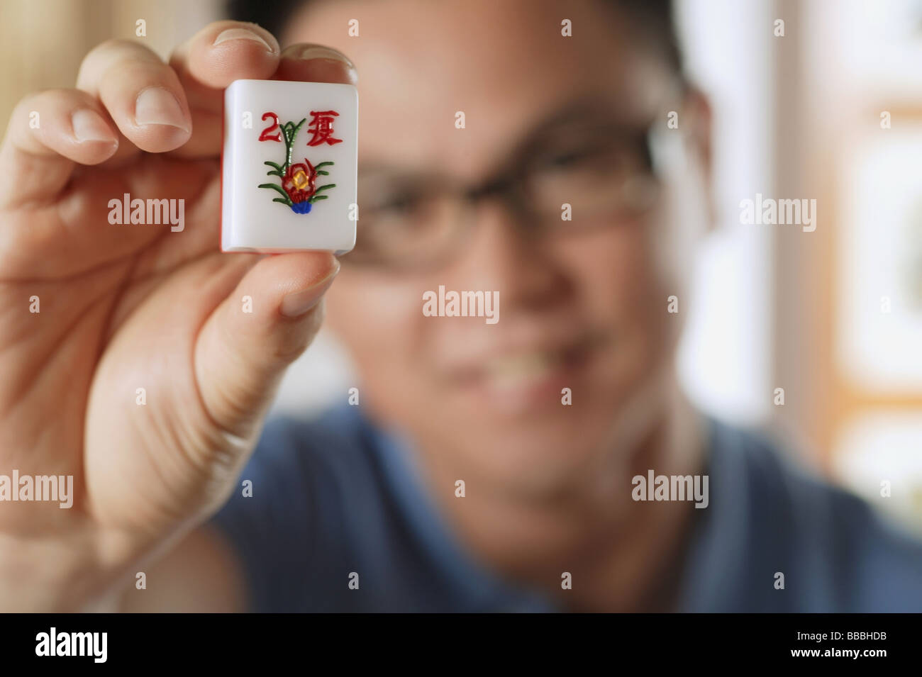 Man holding mahjong tile with the Chinese script for Summer Stock Photo ...