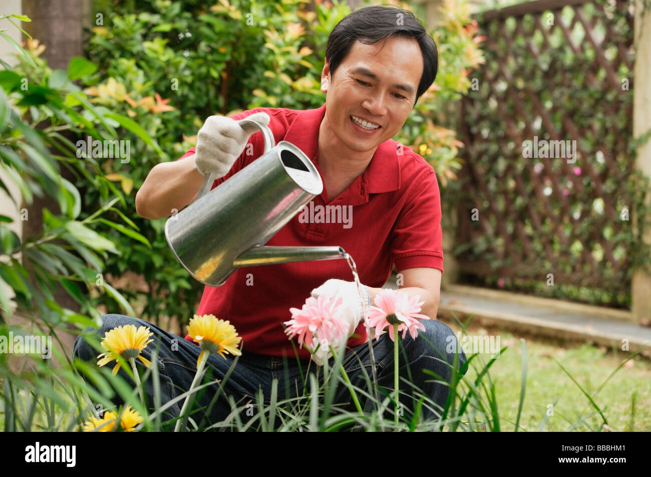 Man watering plants in the garden Stock Photo - Alamy