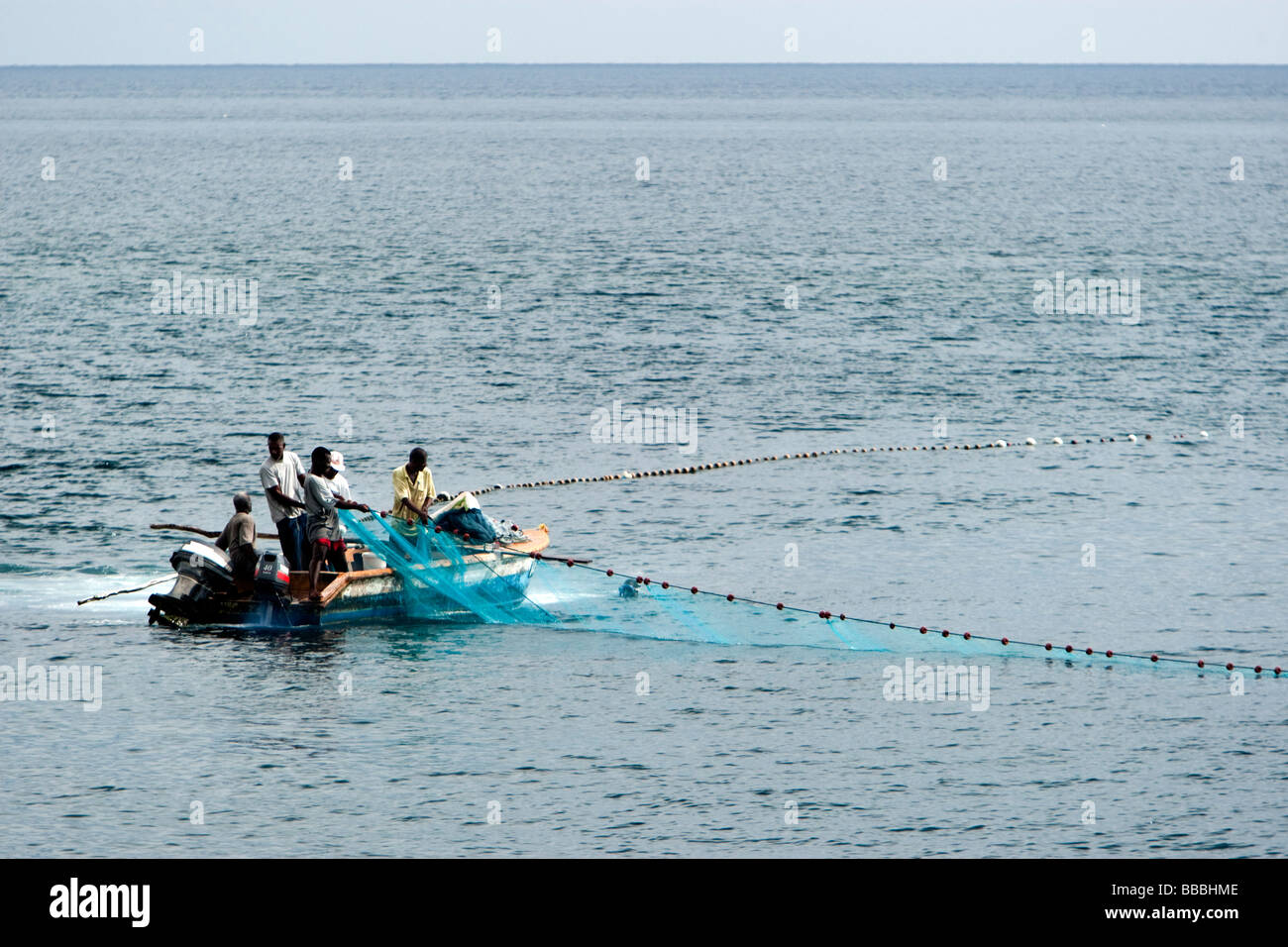 Local fishermen hauling fishing net on small boat off St Kitts ...