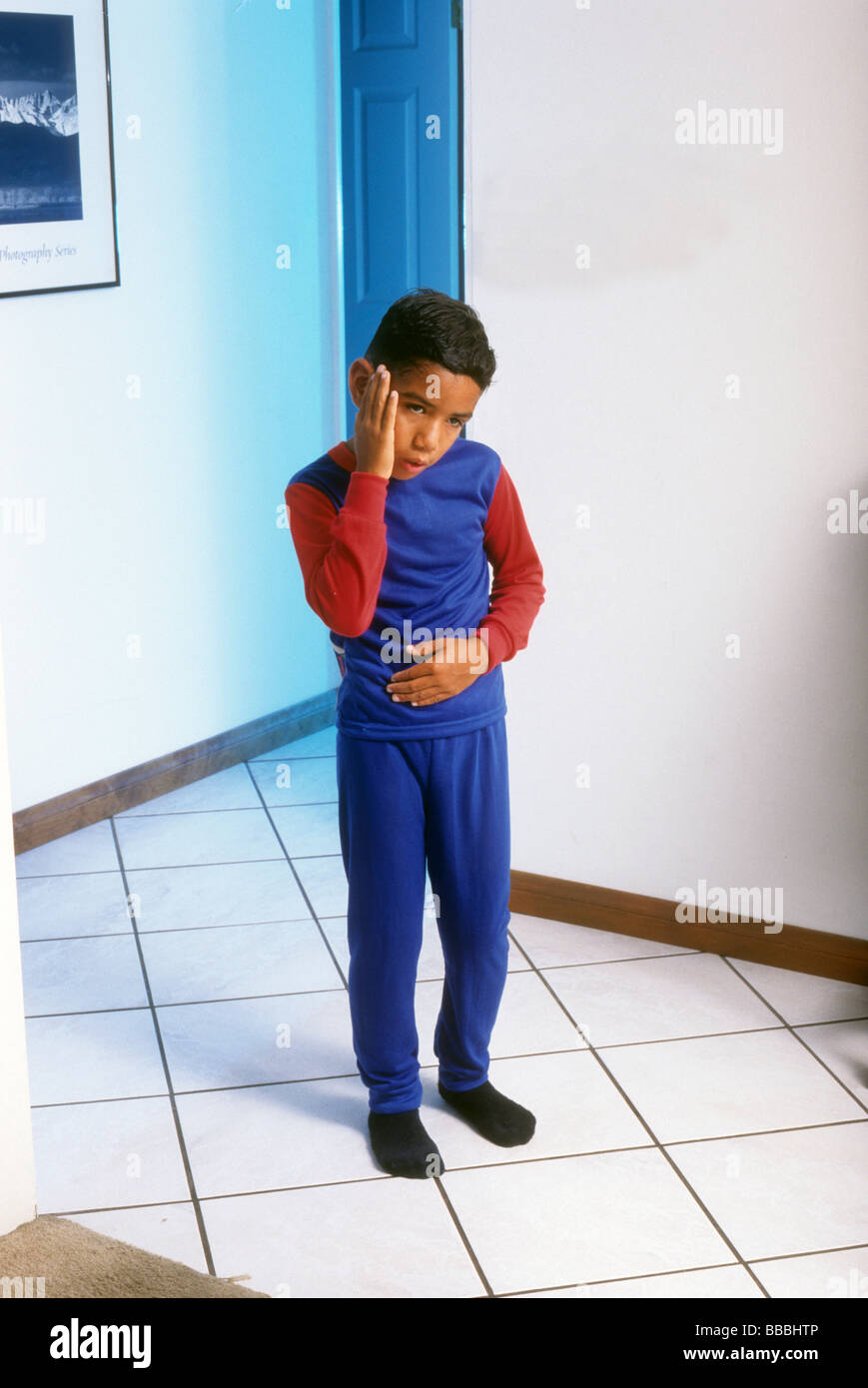 Hispanic Latin boy pajama has tummy stomach ache sad unhappy pain sick ...