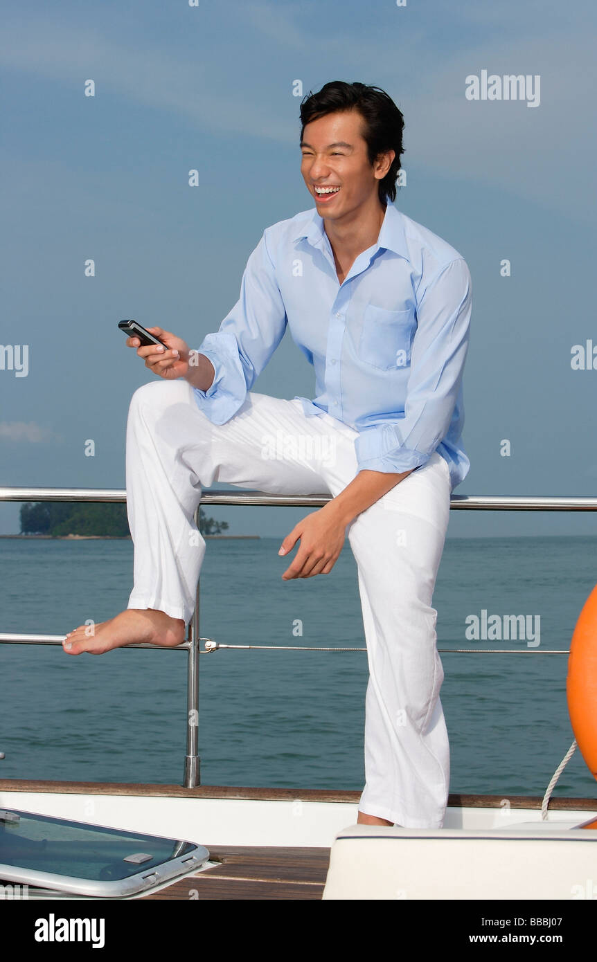 Man with mobile phone on yacht Stock Photo - Alamy