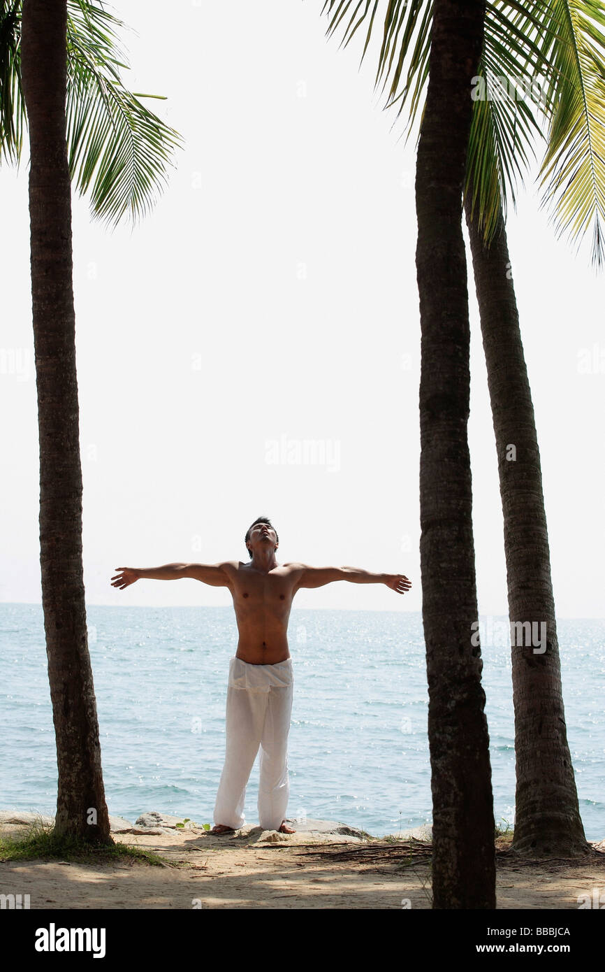 Shirtless man standing between trees, arms outstretched Stock Photo - Alamy