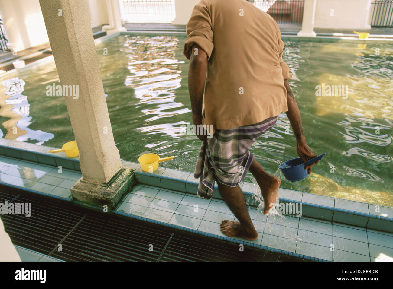 Malaysia, Penang, Indian Muslim washing his feet in a ritual of ...