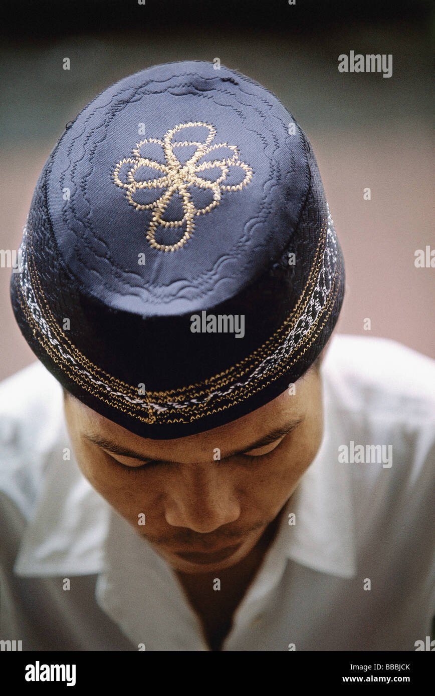 Indonesia, Jakarta, Worshipper wears an embroidered prayer cap, called ...