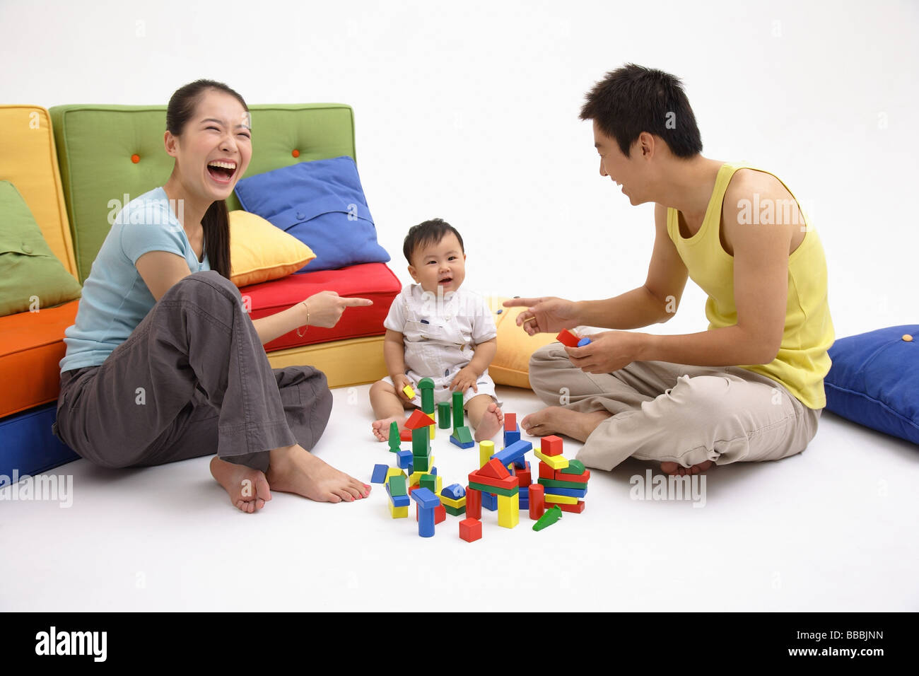 Family with one child, sitting on floor, playing with toys Stock Photo ...
