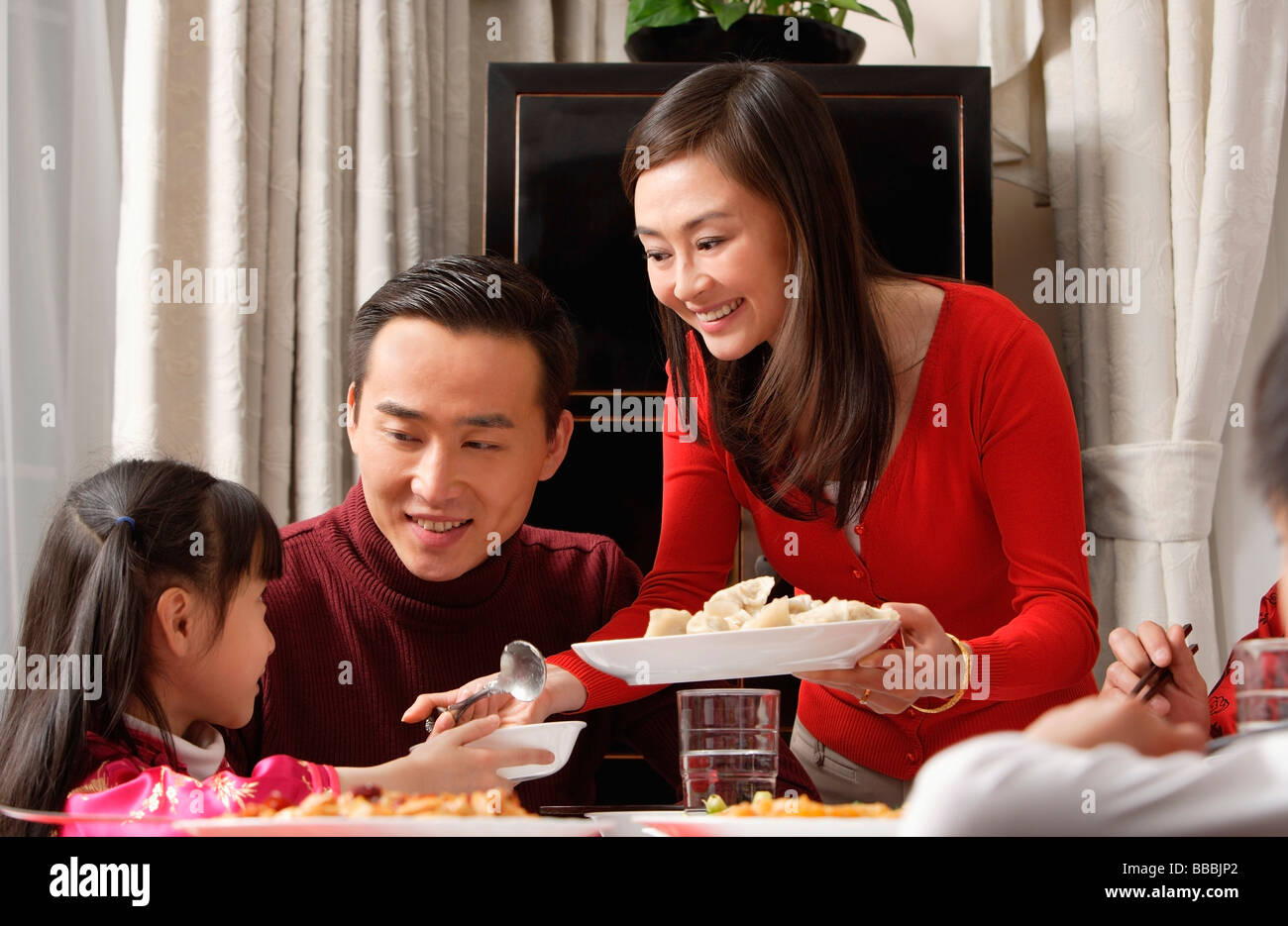 Young mother dishing up food Stock Photo - Alamy