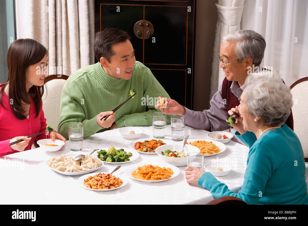Family at dinner table having traditional food Stock Photo - Alamy