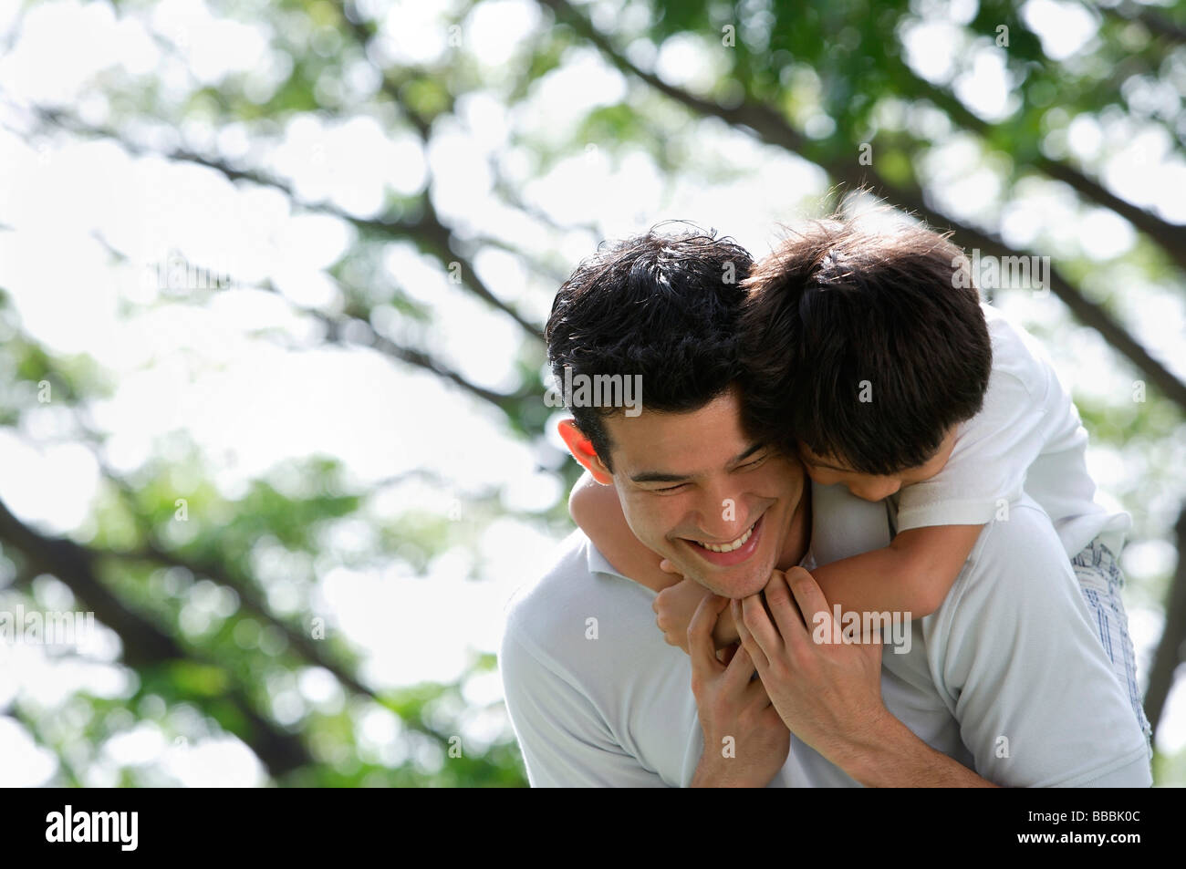 Chinese father and son playing at the park, hugging Stock Photo - Alamy