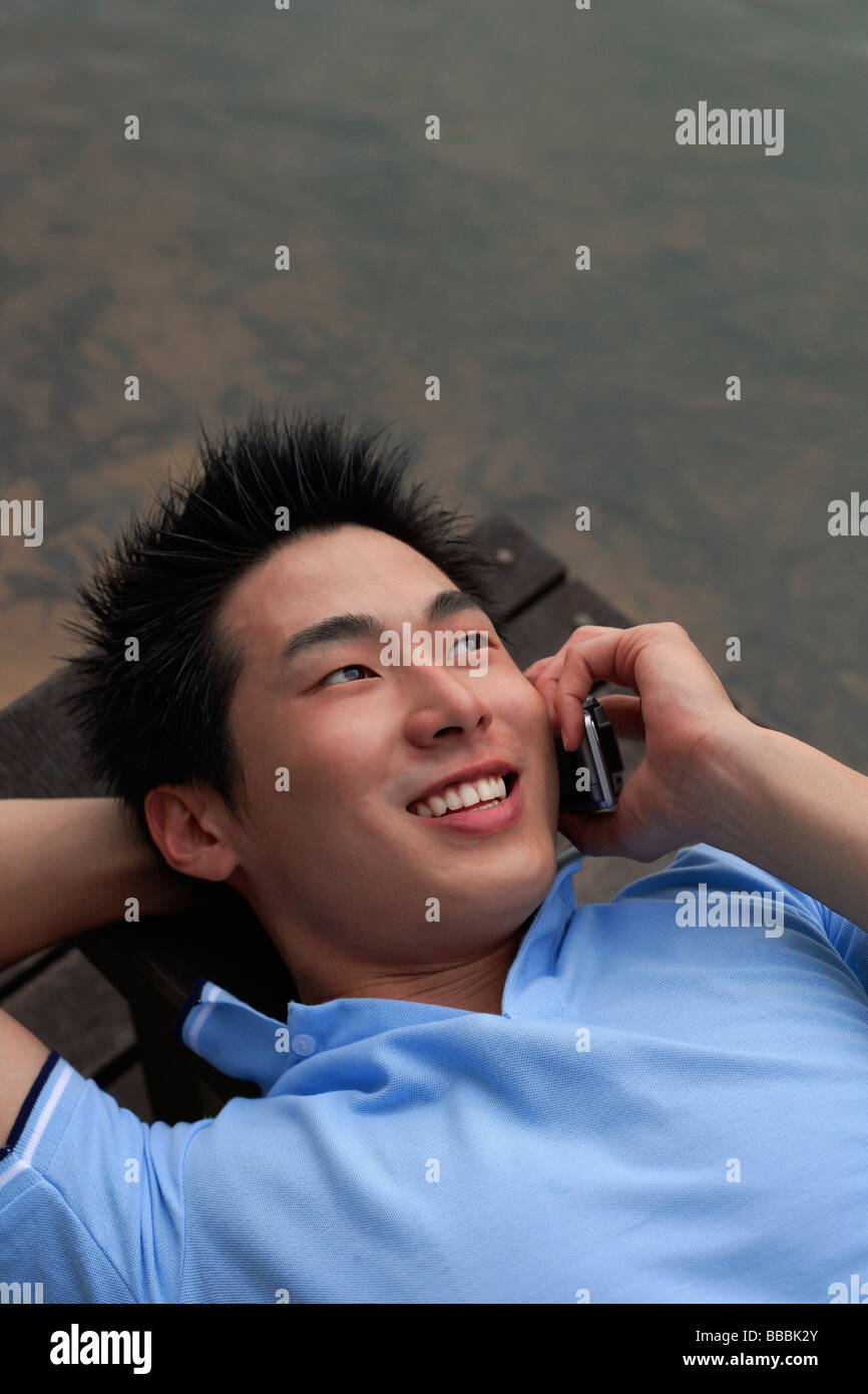 Man lying down, using mobile phone Stock Photo - Alamy