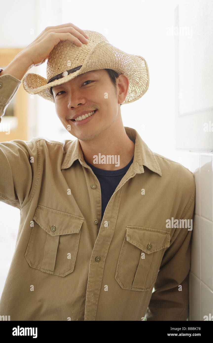Man in cowboy hat, hand on head, smiling at camera Stock Photo - Alamy