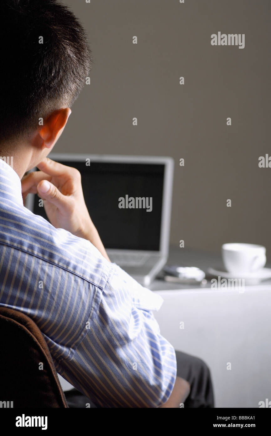 Man using laptop, rear view Stock Photo - Alamy