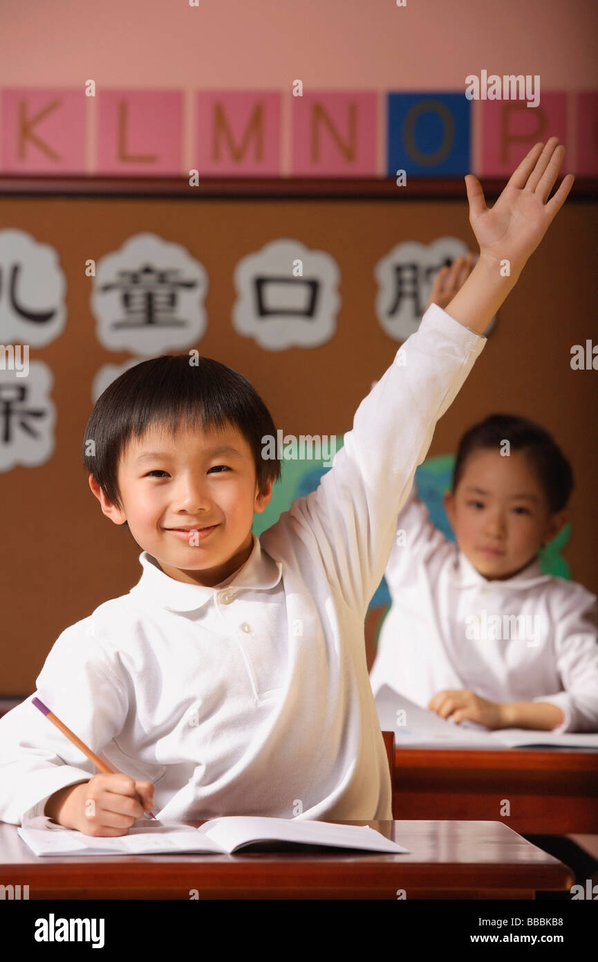 Students in class raising hands Stock Photo - Alamy