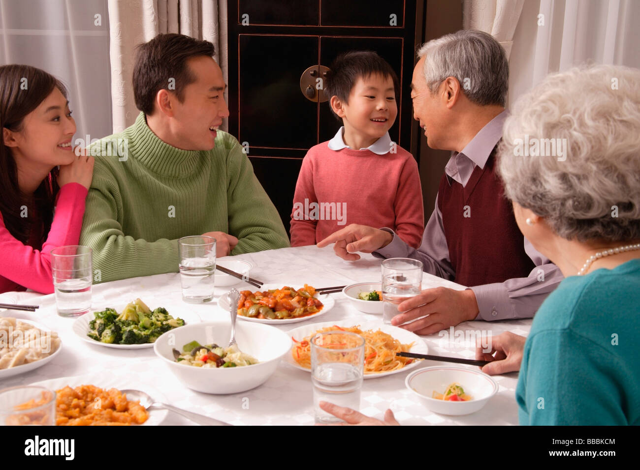 Family chatting over at dinner table having traditional food Stock ...