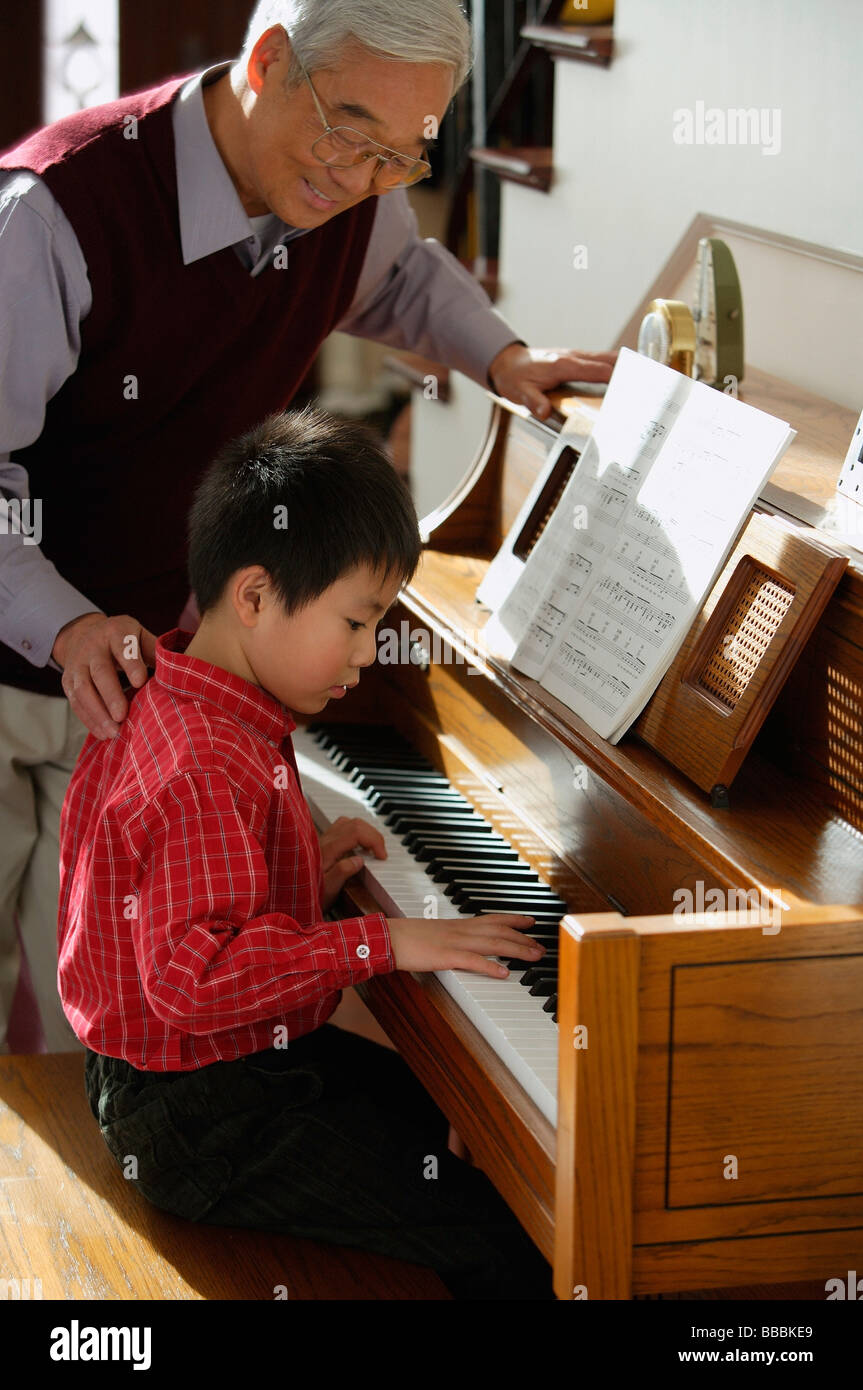 Boy playing piano for grandfather Stock Photo - Alamy