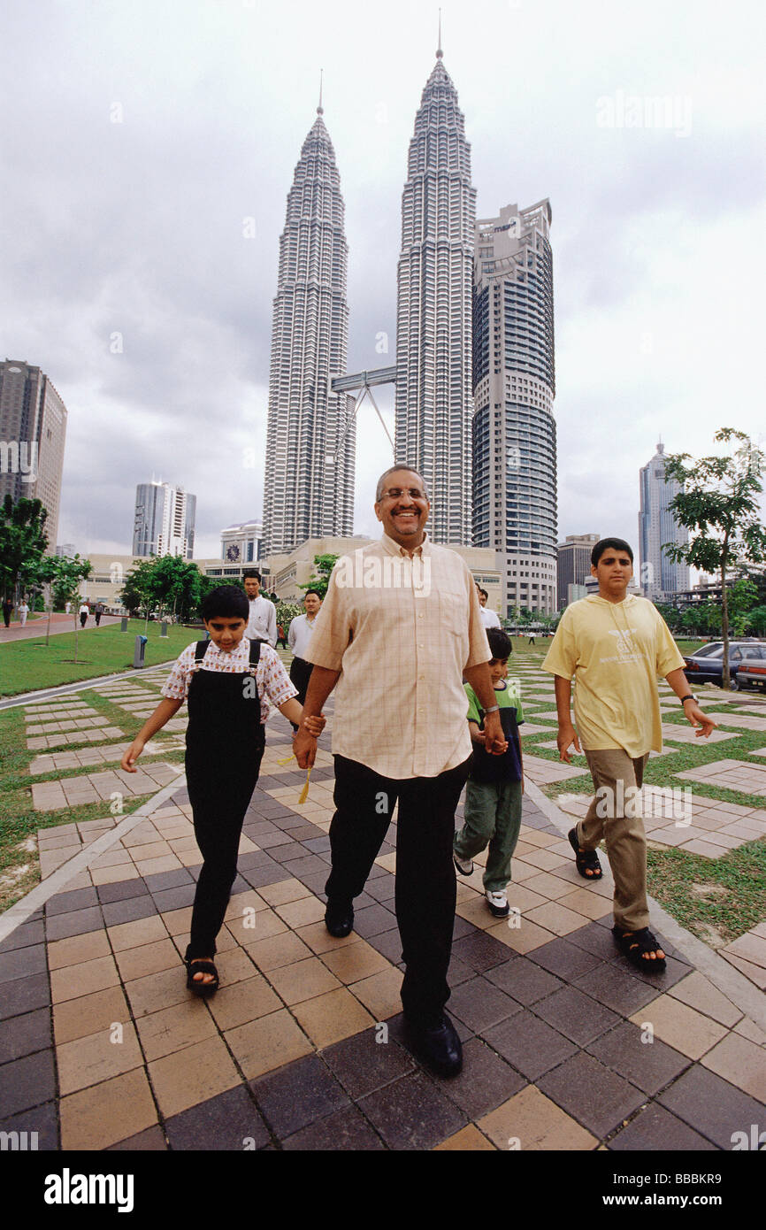 Malaysia, Kuala Lumpur, Malay family walking, Petronas Twin Towers in ...