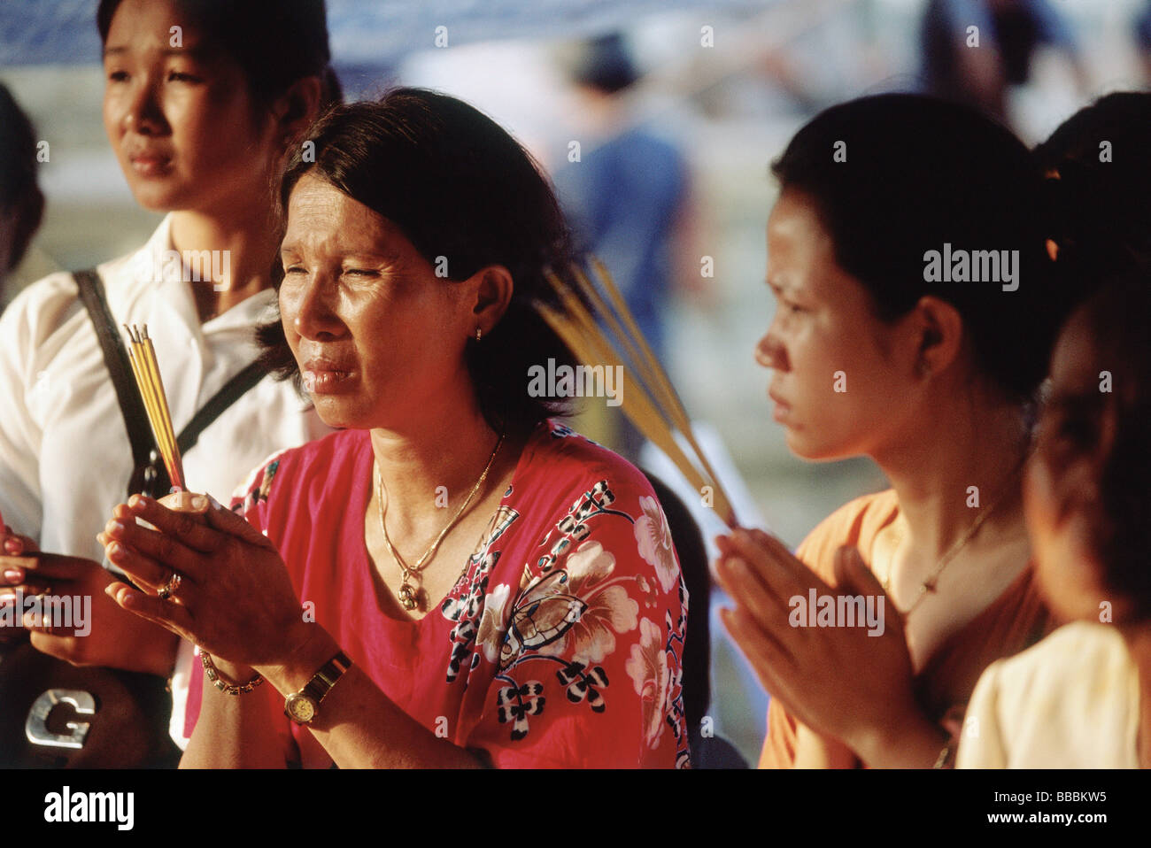 Cambodia, Phnom Penh, Worshippers praying with incense at a temple ...