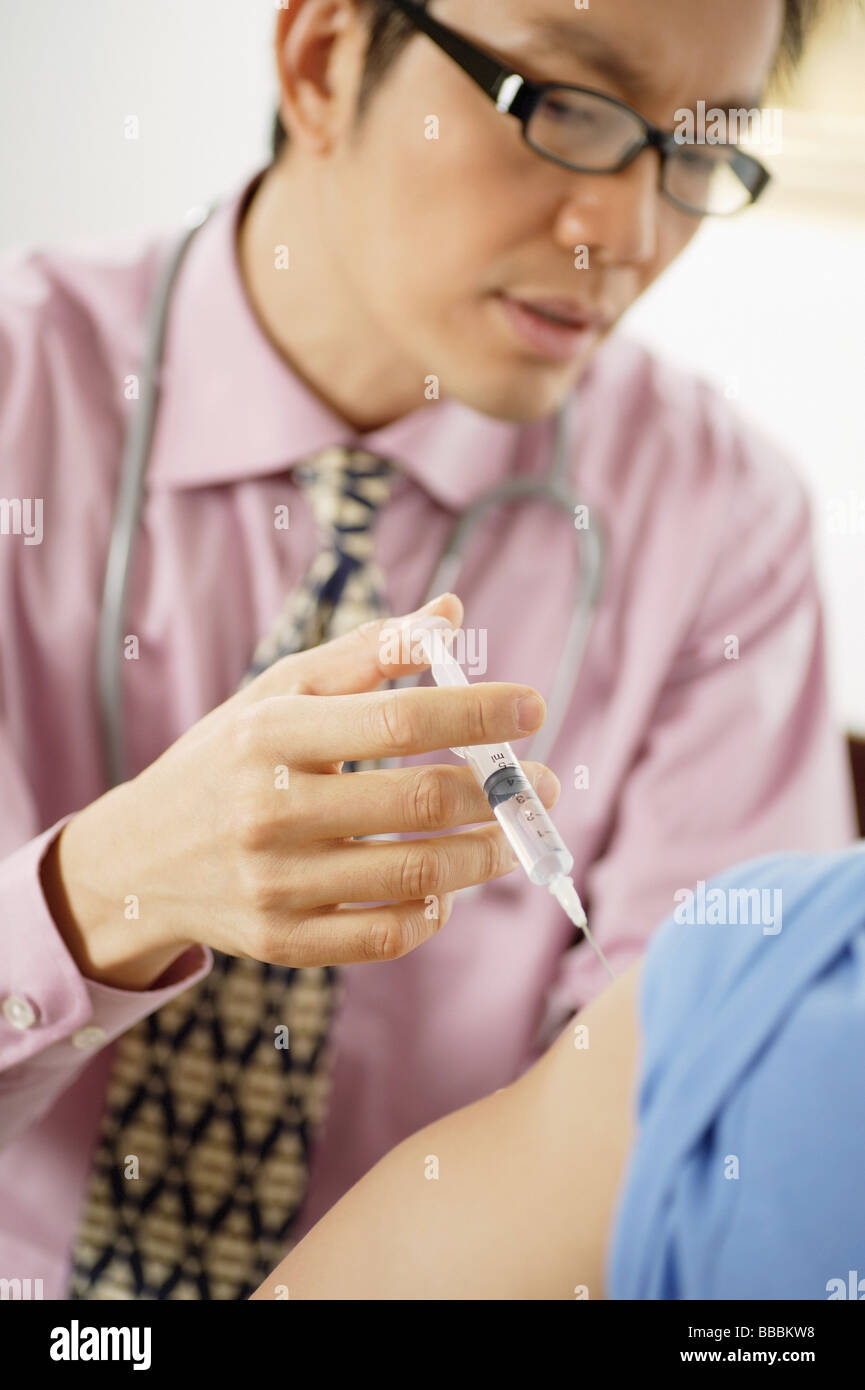 Doctor injecting patient Stock Photo - Alamy