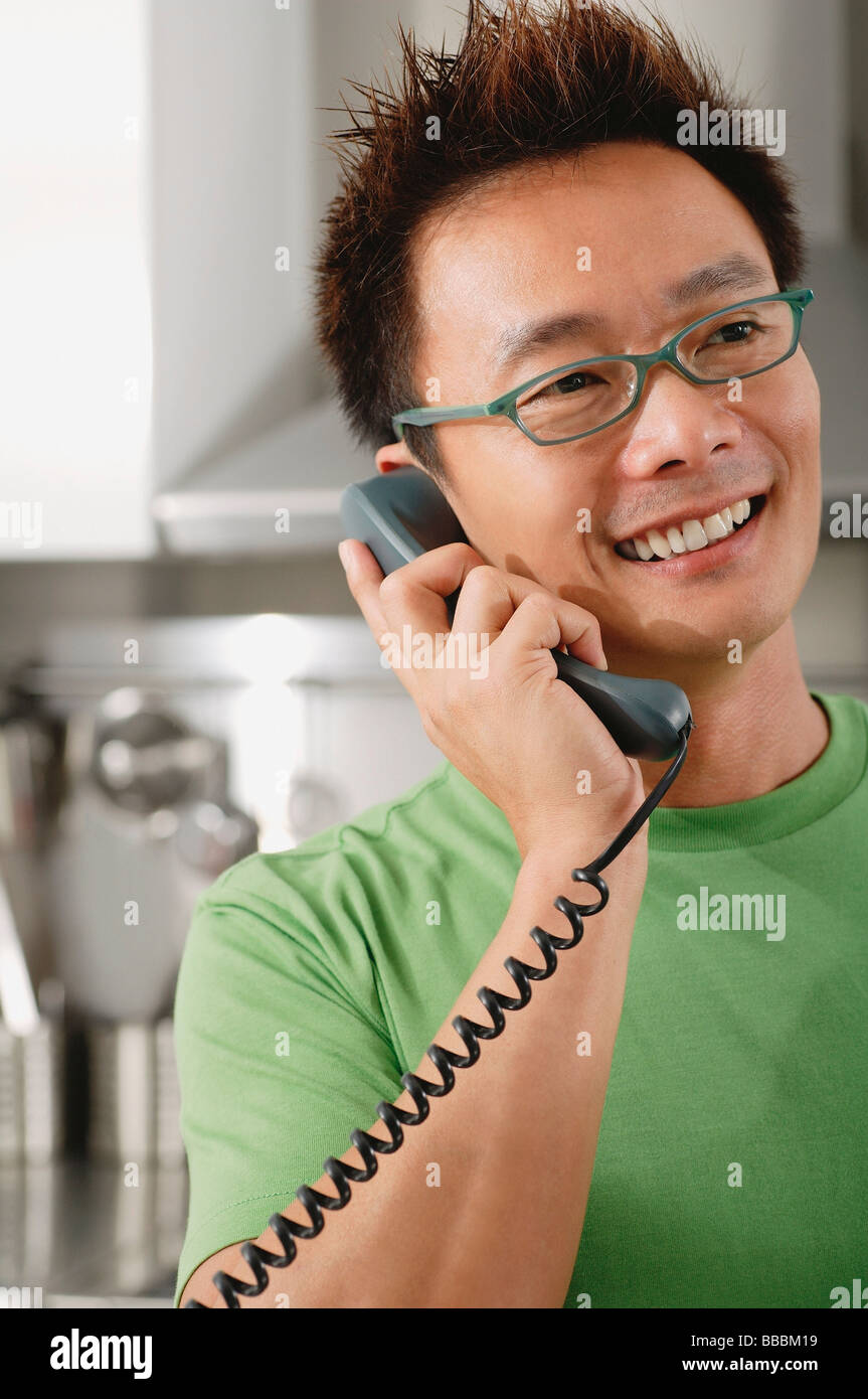 Man in kitchen, using telephone Stock Photo - Alamy