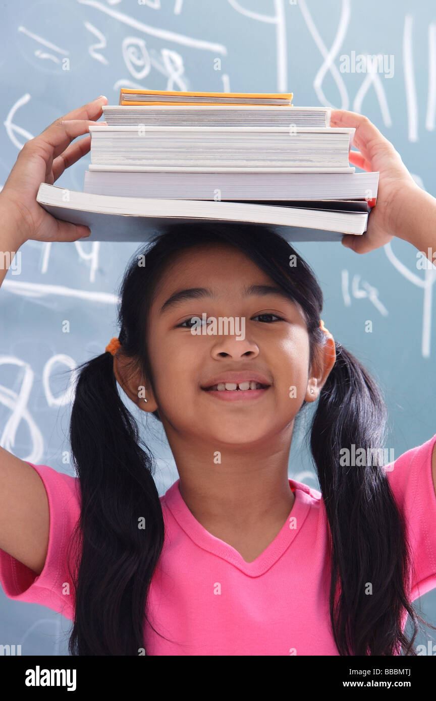 girl with books stacked on head Stock Photo - Alamy