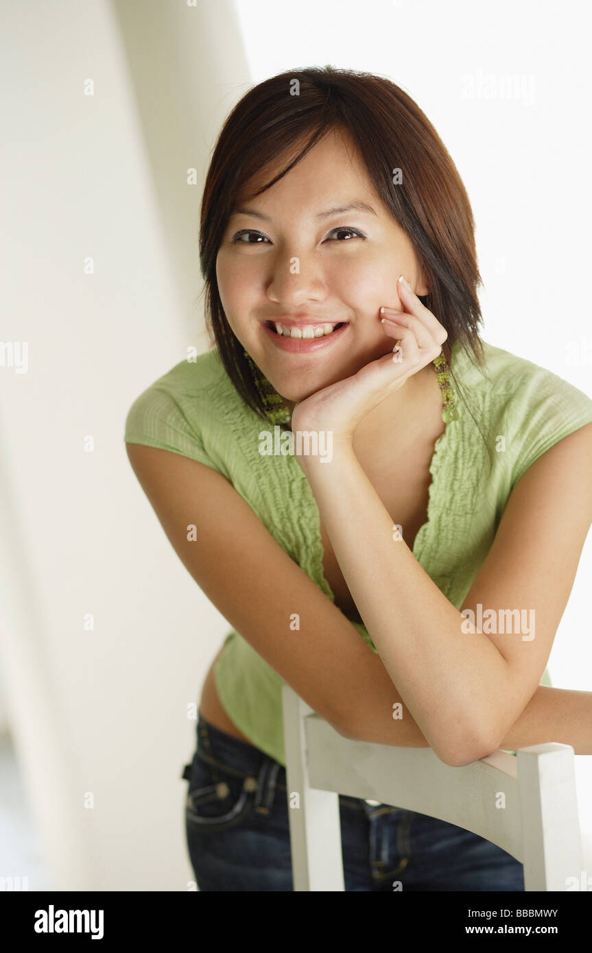 Woman leaning on back of chair smiling at camera Stock Photo - Alamy