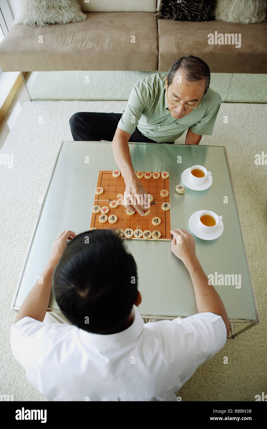 Older man playing Chinese chess with younger man Stock Photo - Alamy