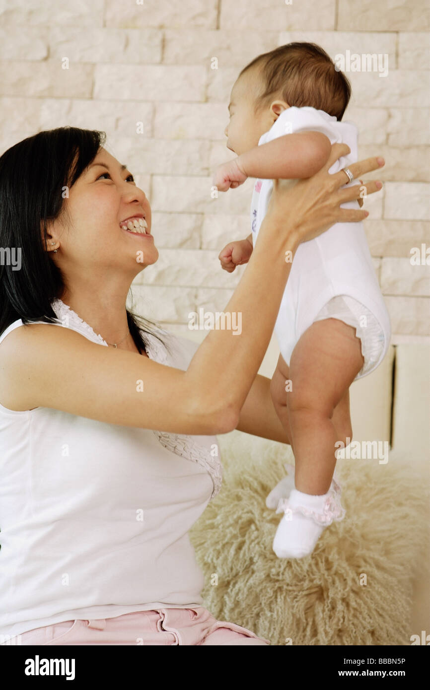 Mother carrying baby Stock Photo - Alamy