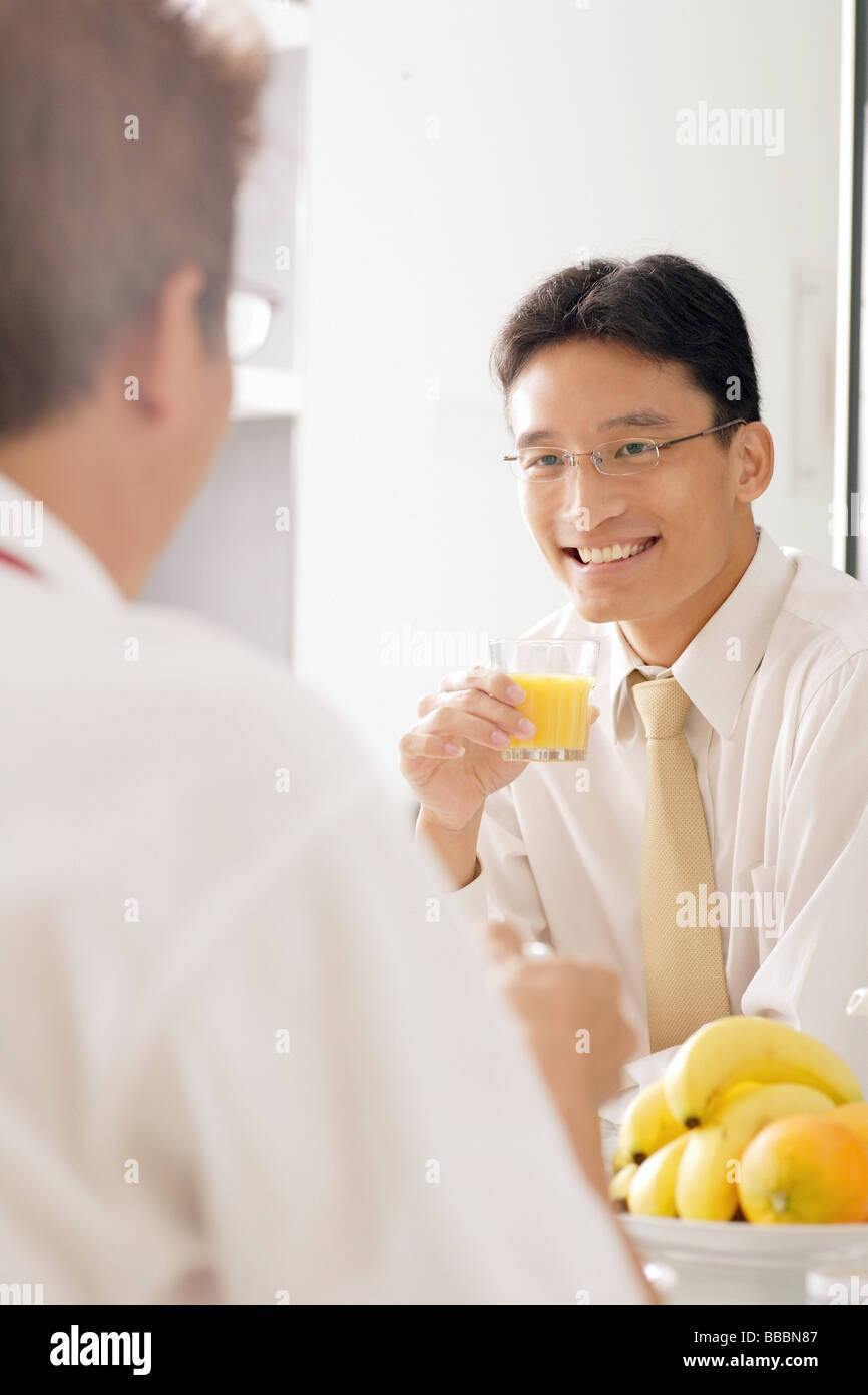 Two men facing each other, one drinking juice Stock Photo - Alamy
