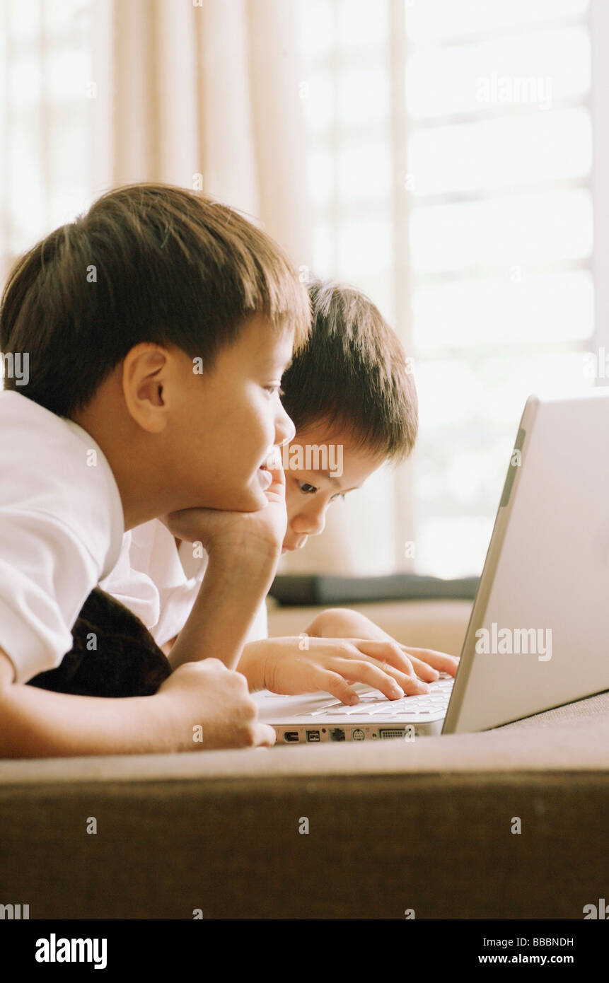 Two children using laptop, side by side Stock Photo - Alamy