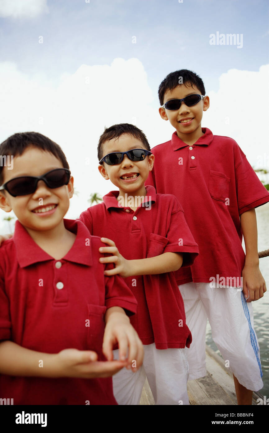Three boys standing in a row Stock Photo - Alamy