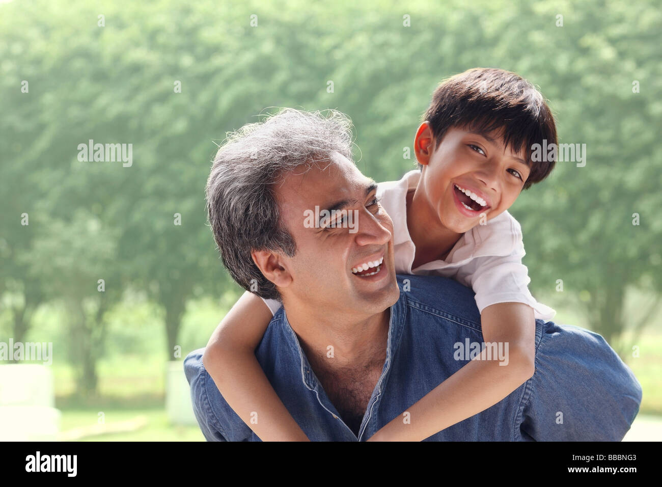 Father with son on his back, son smiling at camera Stock Photo - Alamy