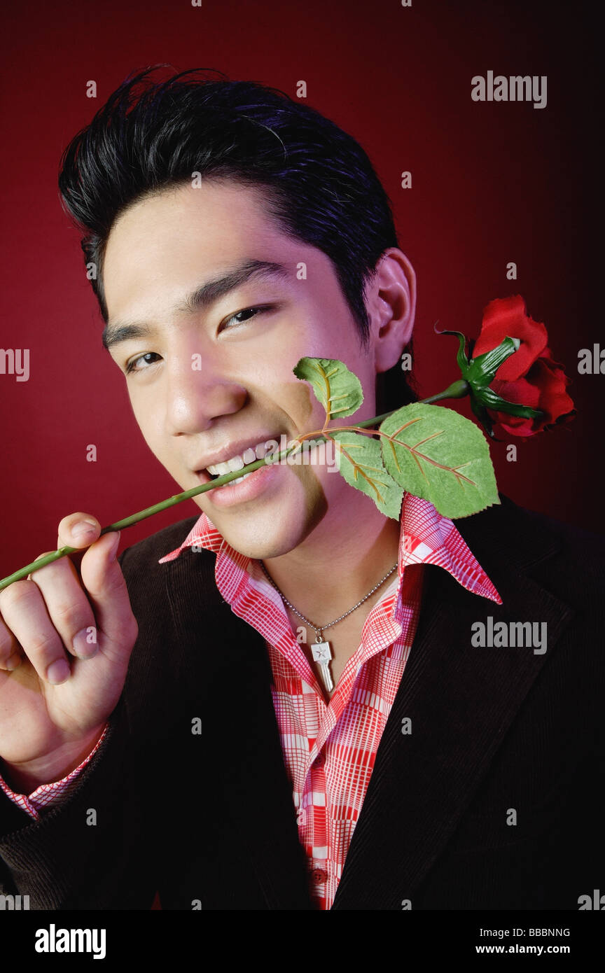 Man with rose stalk between his teeth Stock Photo - Alamy