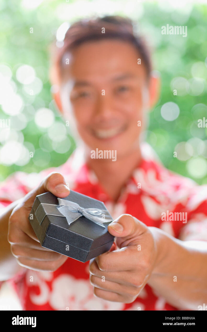 Man holding gift towards camera Stock Photo - Alamy