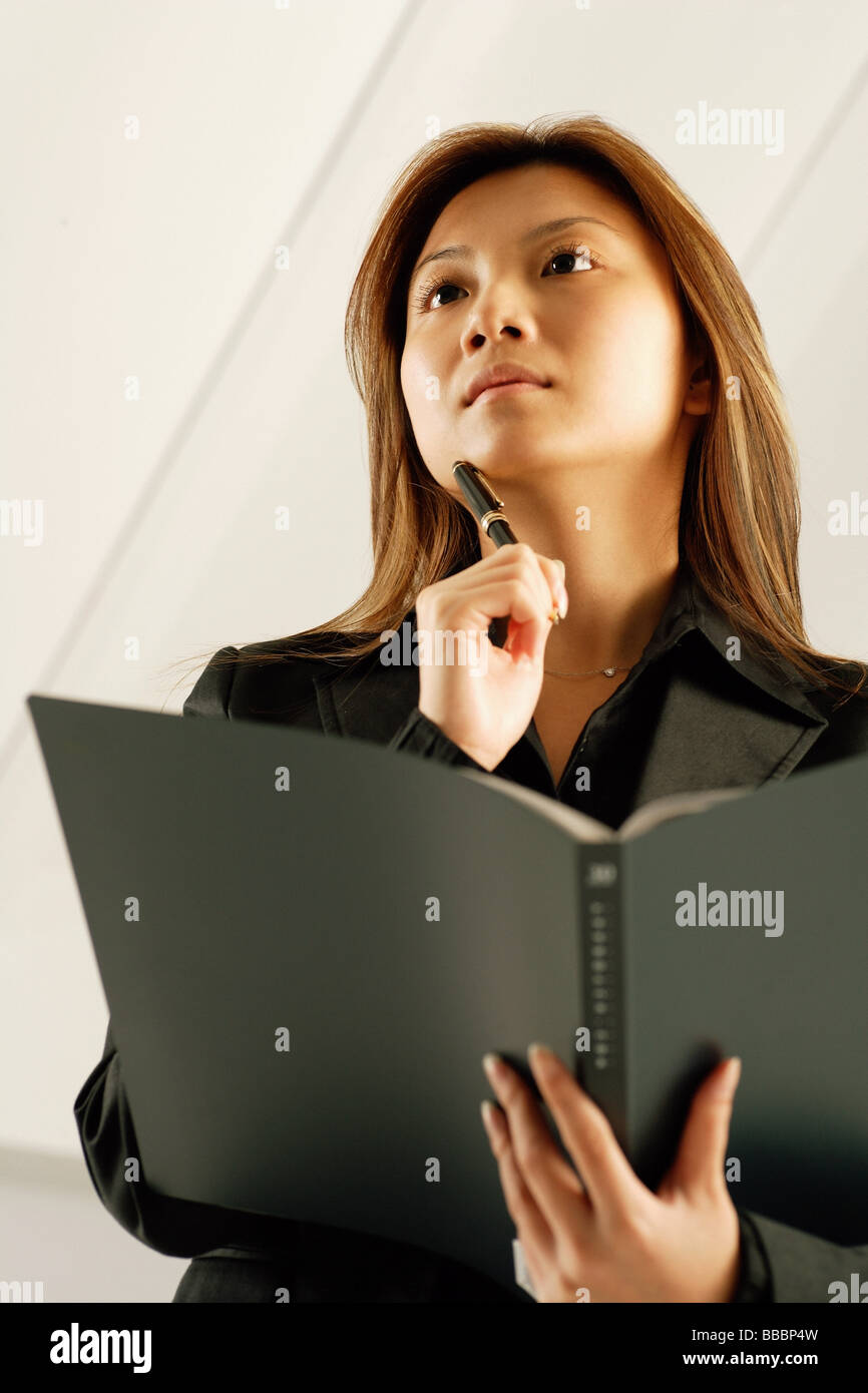 Young woman, holding pen and file Stock Photo - Alamy